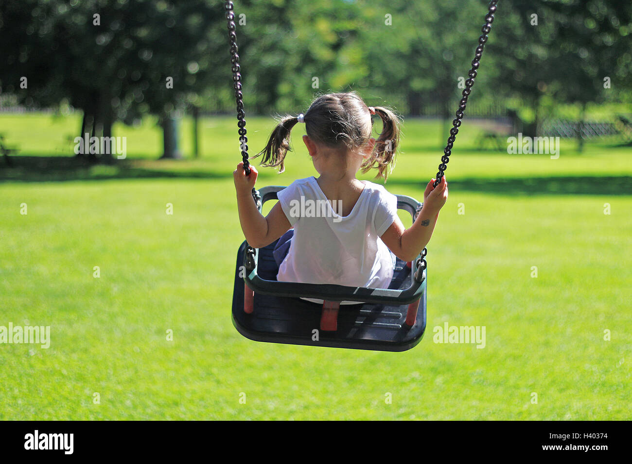 Rear view of girl on a swing Stock Photo - Alamy