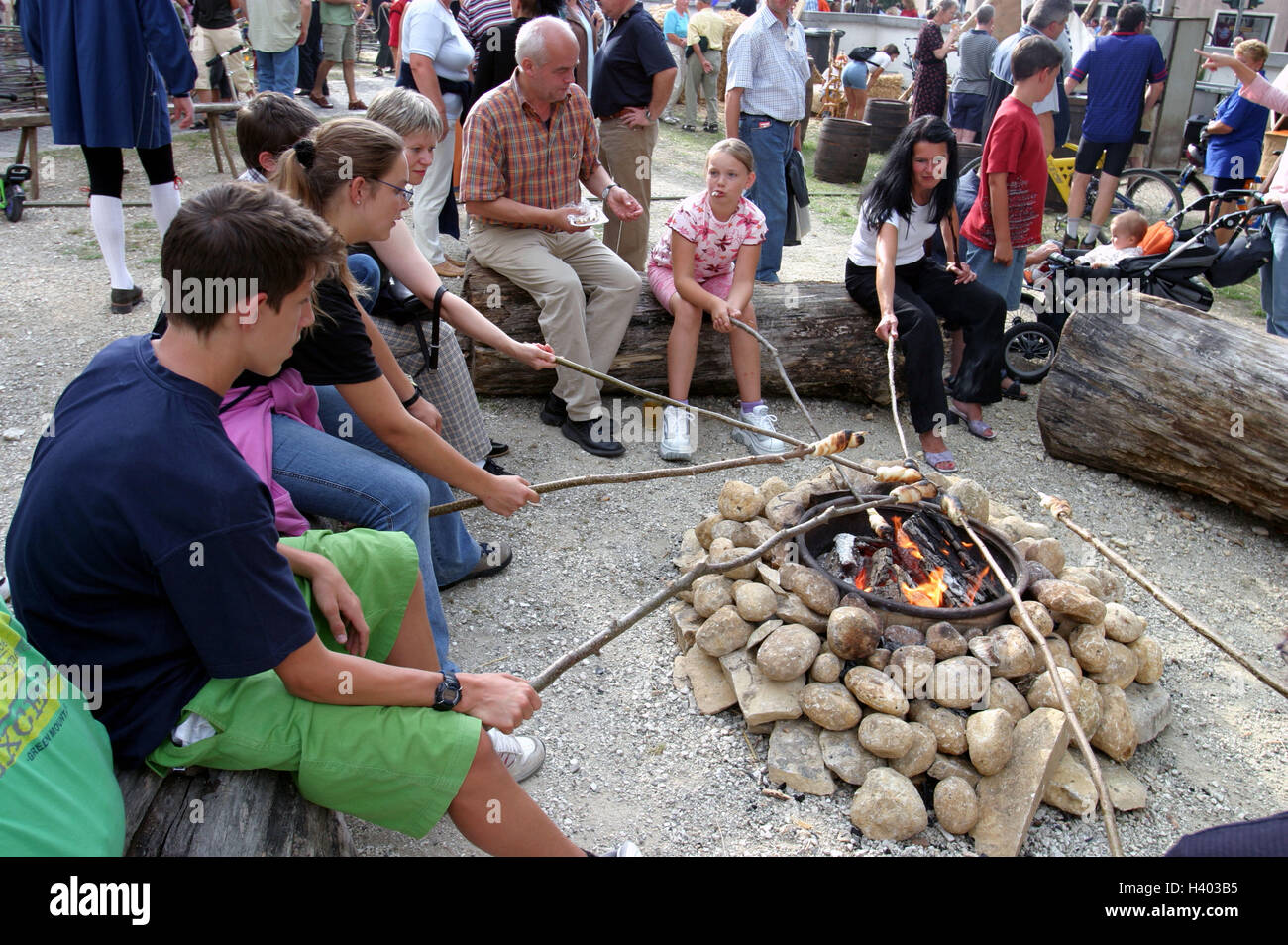 Town feast, campfire, trunks, children, adults, sit, eat barbecue, no ...