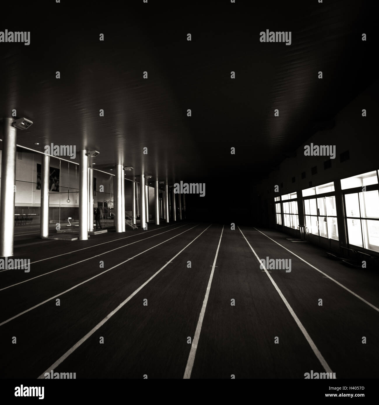 The lines of an indoor running track merge into the infinite darkness ...