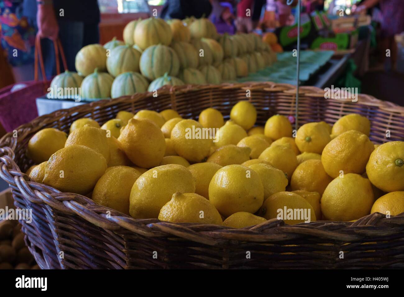 Basket of lemons and stack of melons Stock Photo - Alamy