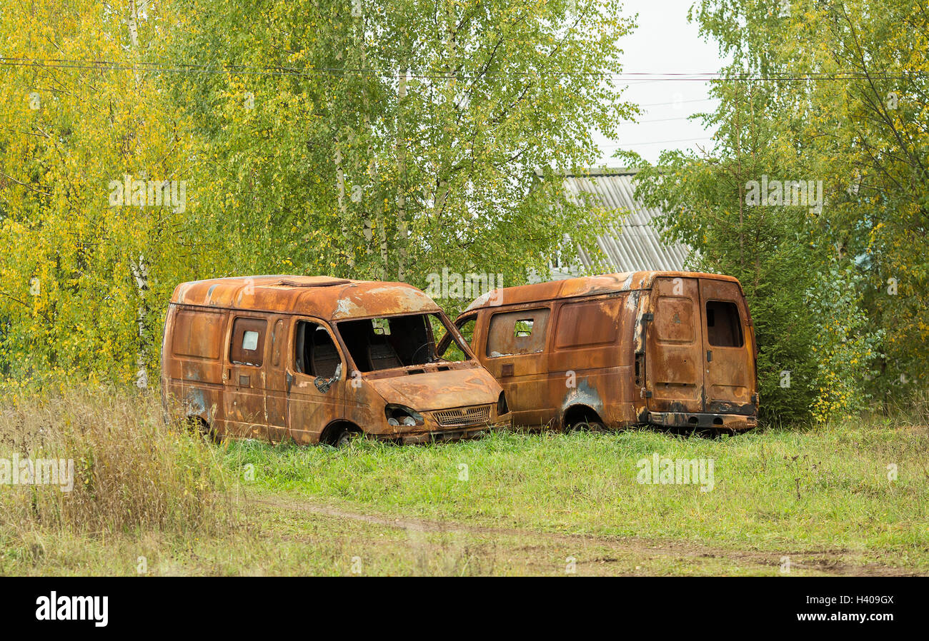 Two rusty car without wheels stand on forest background Stock Photo - Alamy