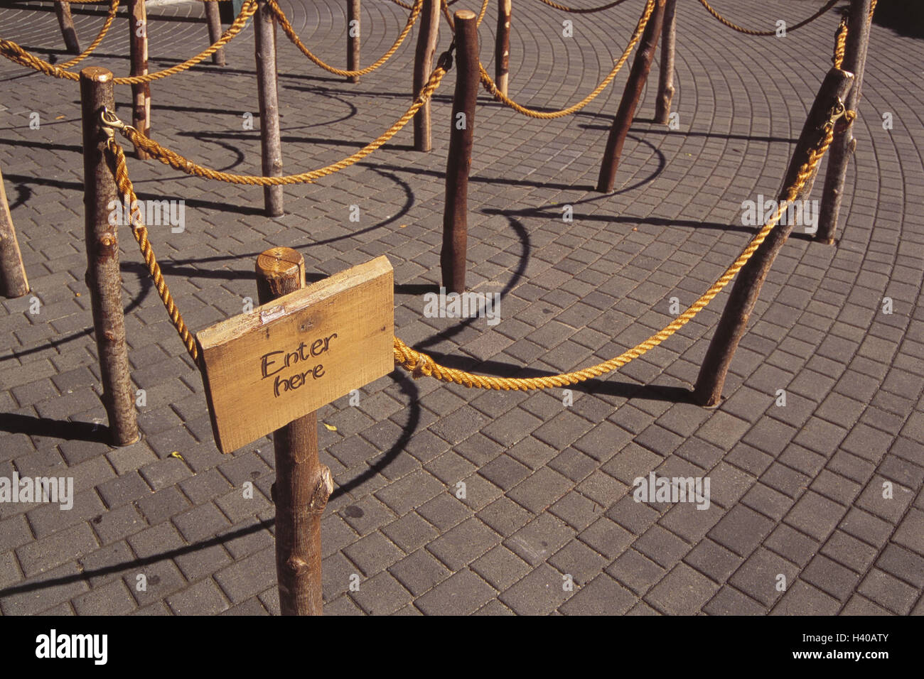 Space, cobblestones, wooden poles, ropes, labyrinth, sign, "Enter here ...