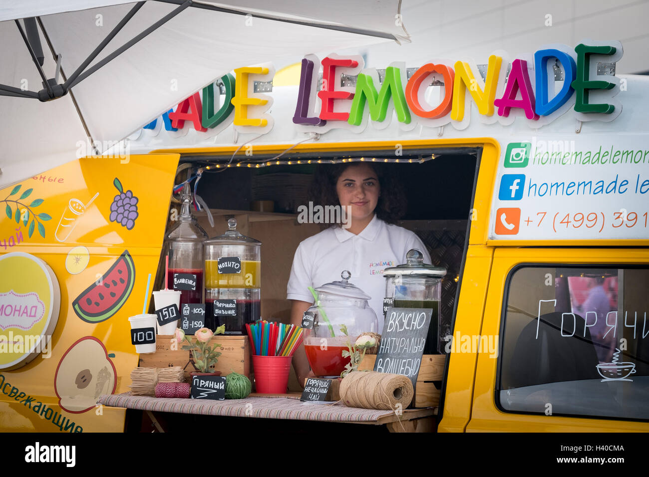 Young woman sells fresh homemade lemonade from food track Stock Photo ...