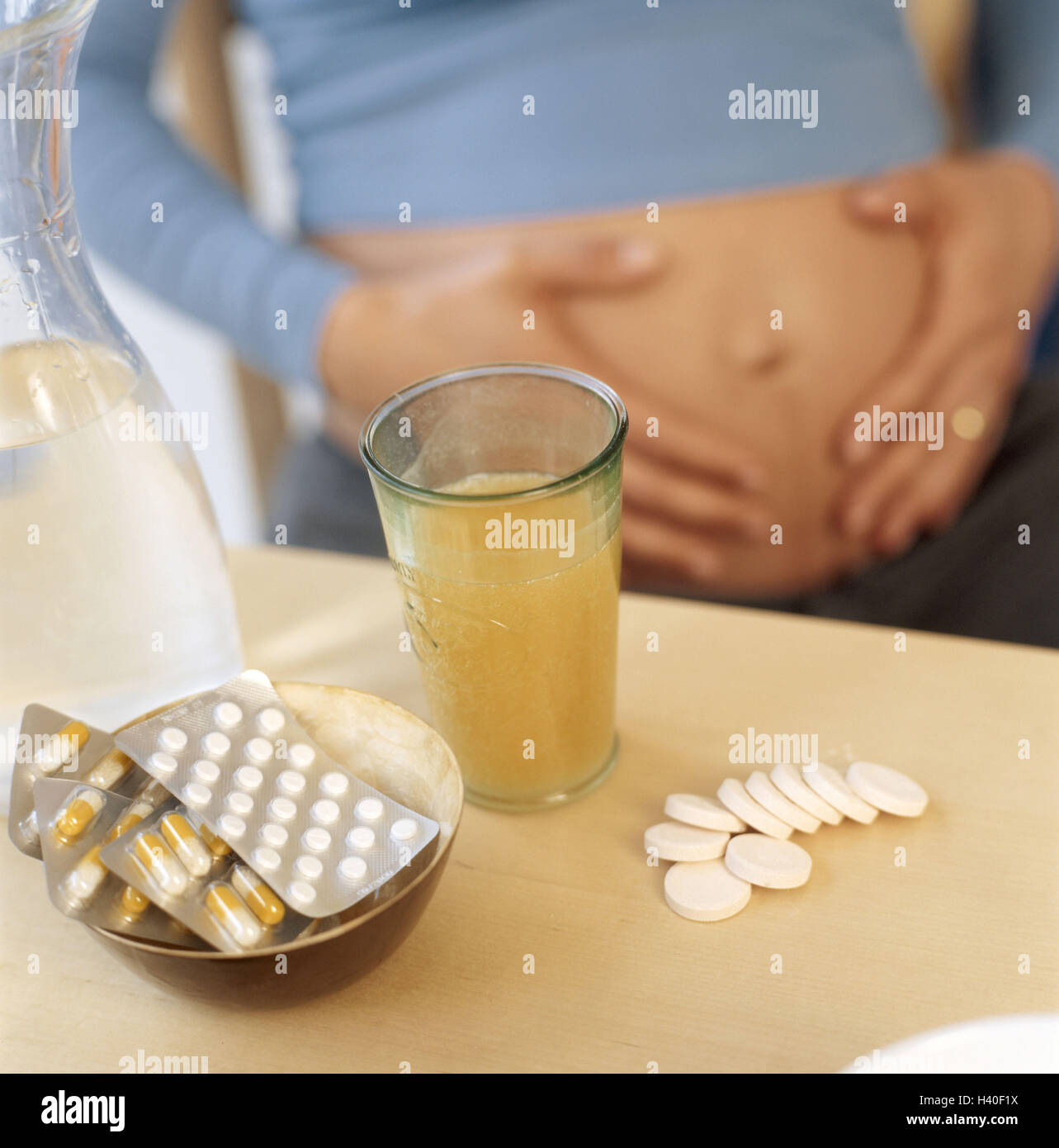 Woman, pregnant, sit, hands, touch, abdomen, table, drugs, capsules ...