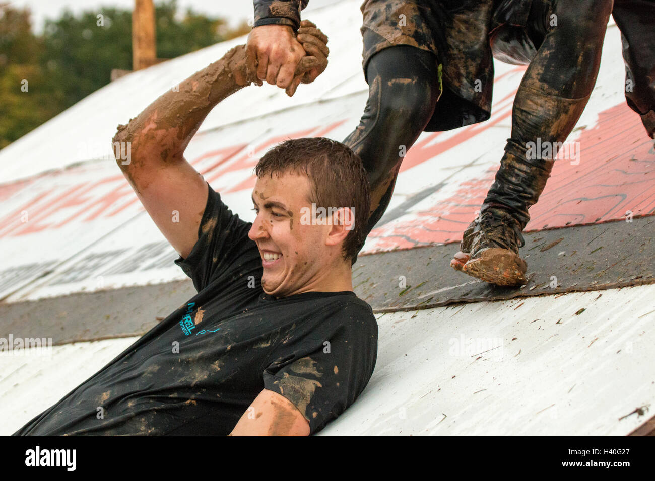 Tough Mudder competitors at an obstacle climbing the angle wall Pyramid ...