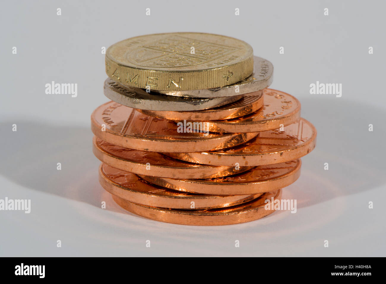 Stack of shiny, copper and silver coins ( 2p, 20p, £1) seen in close-up ...