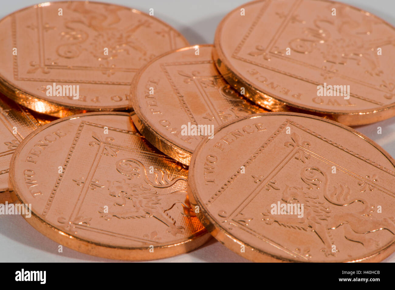 Laid flat and overlapping, 6 shiny, copper, two pence coins, tails up ...