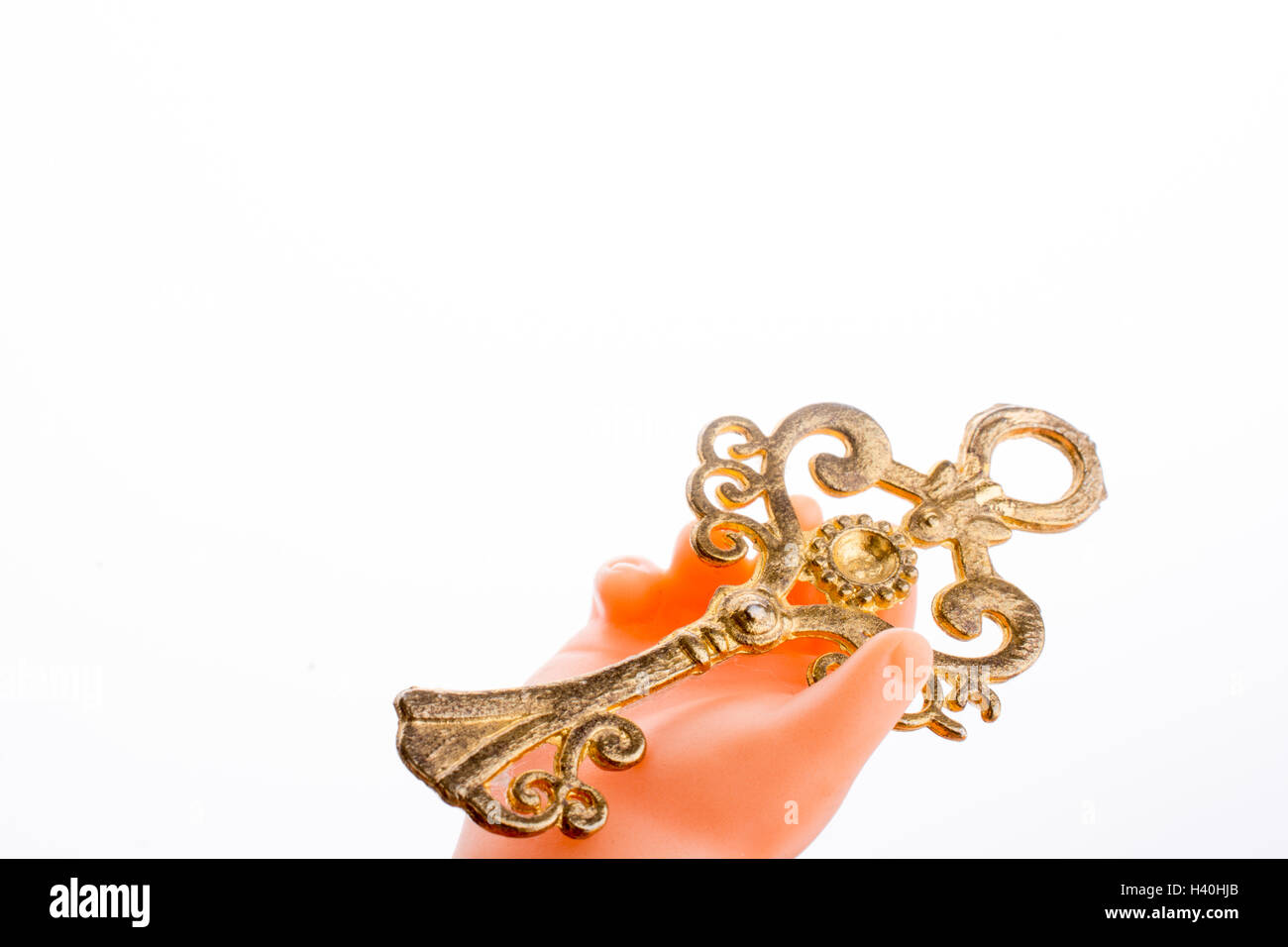 Doll holding a key on a white background Stock Photo - Alamy