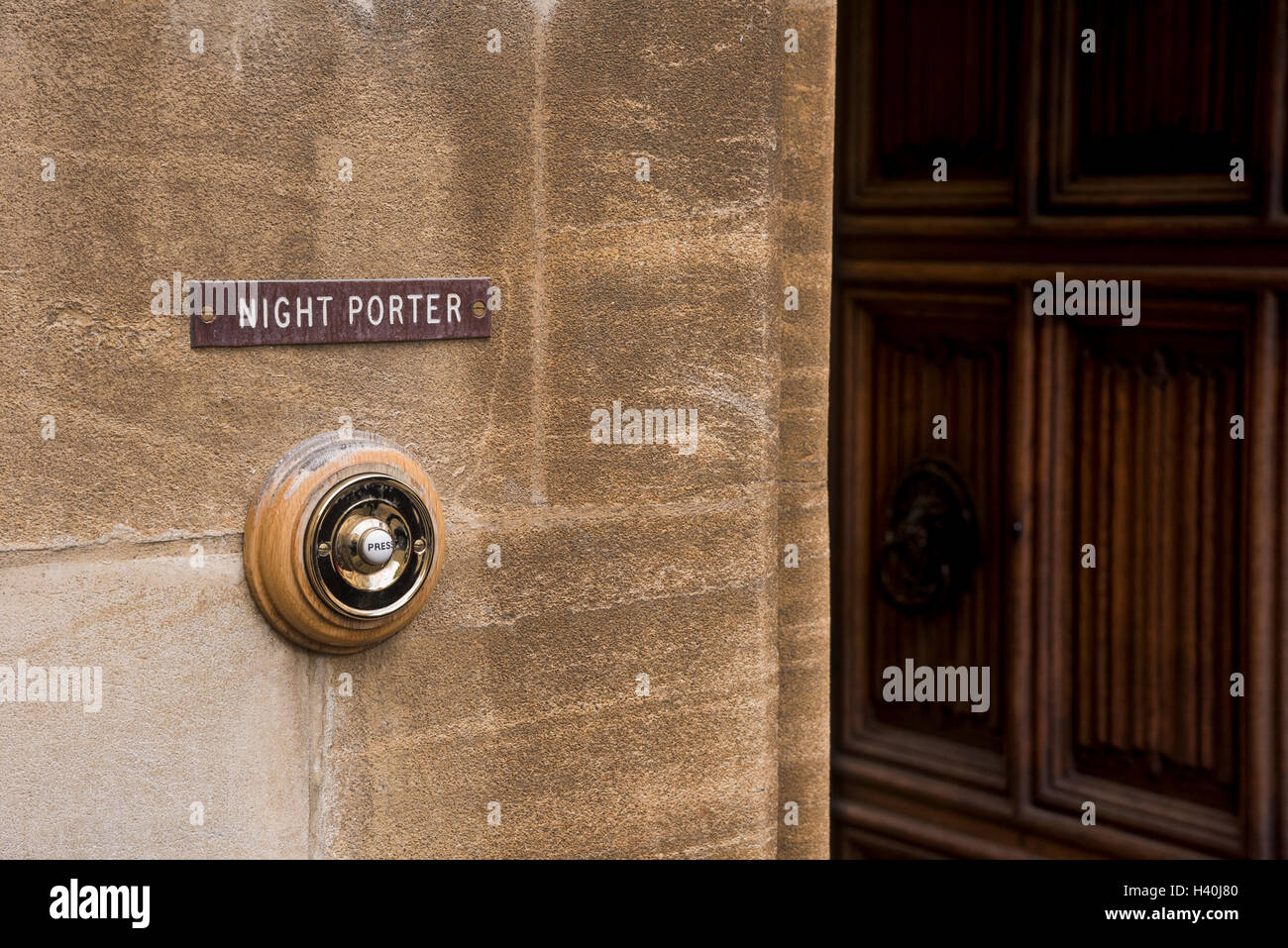 Close-up of the night porter sign and push-button bell on a wall near ...