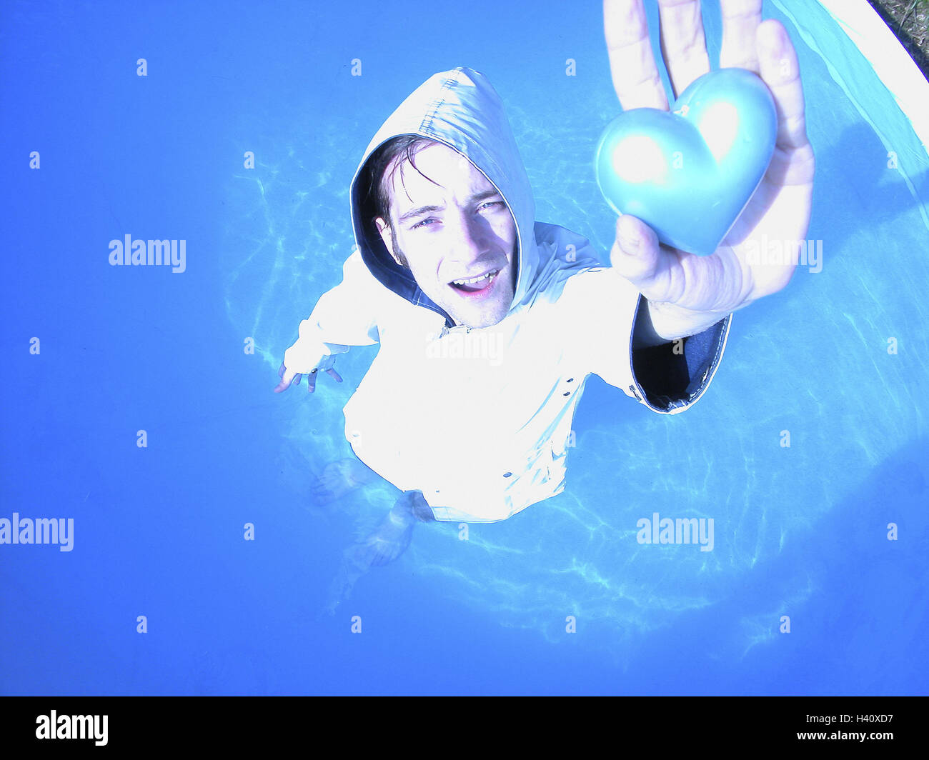Pool, man, young, stand, hold up rain jacket, plastic heart, from above ...
