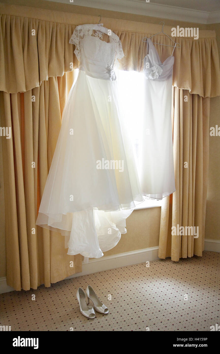 Bride's wedding dress hanging on window hi-res stock photography and ...