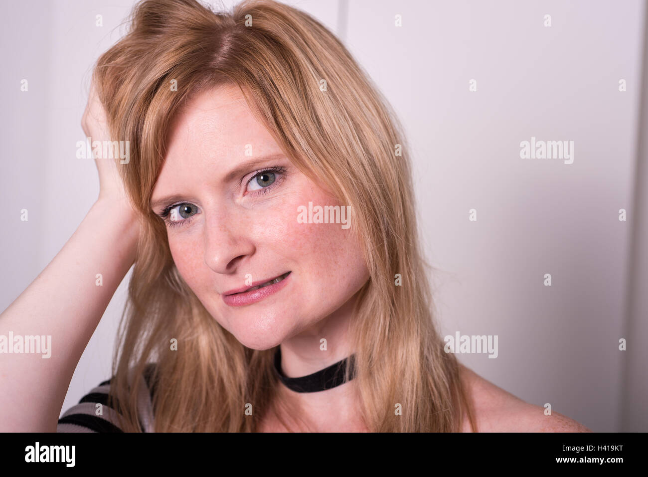 beautiful blonde woman looking into camera and dreaming Stock Photo - Alamy