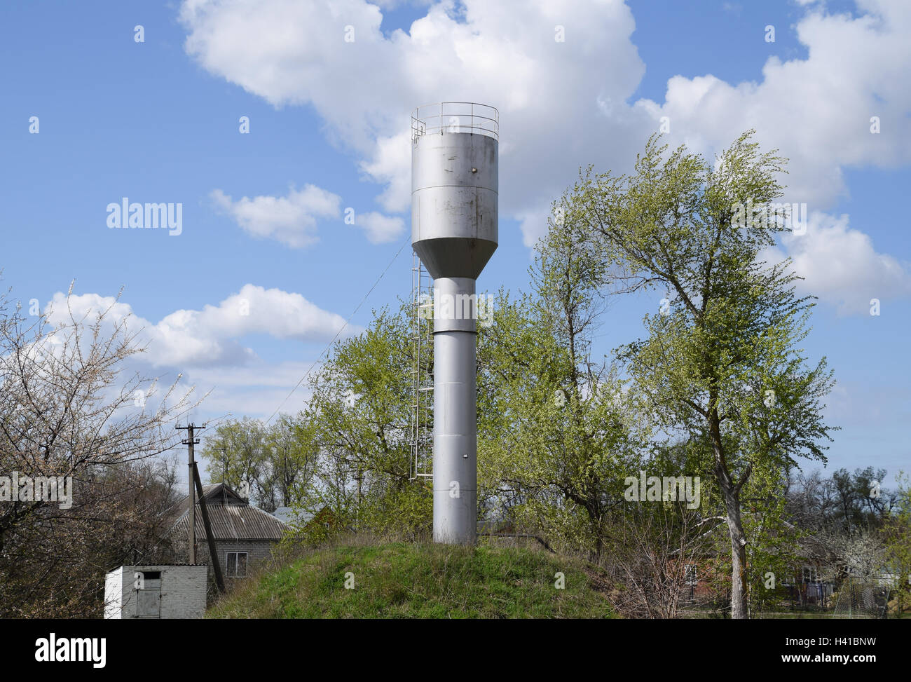 Silver Water Tower among green grass and trees Stock Photo - Alamy