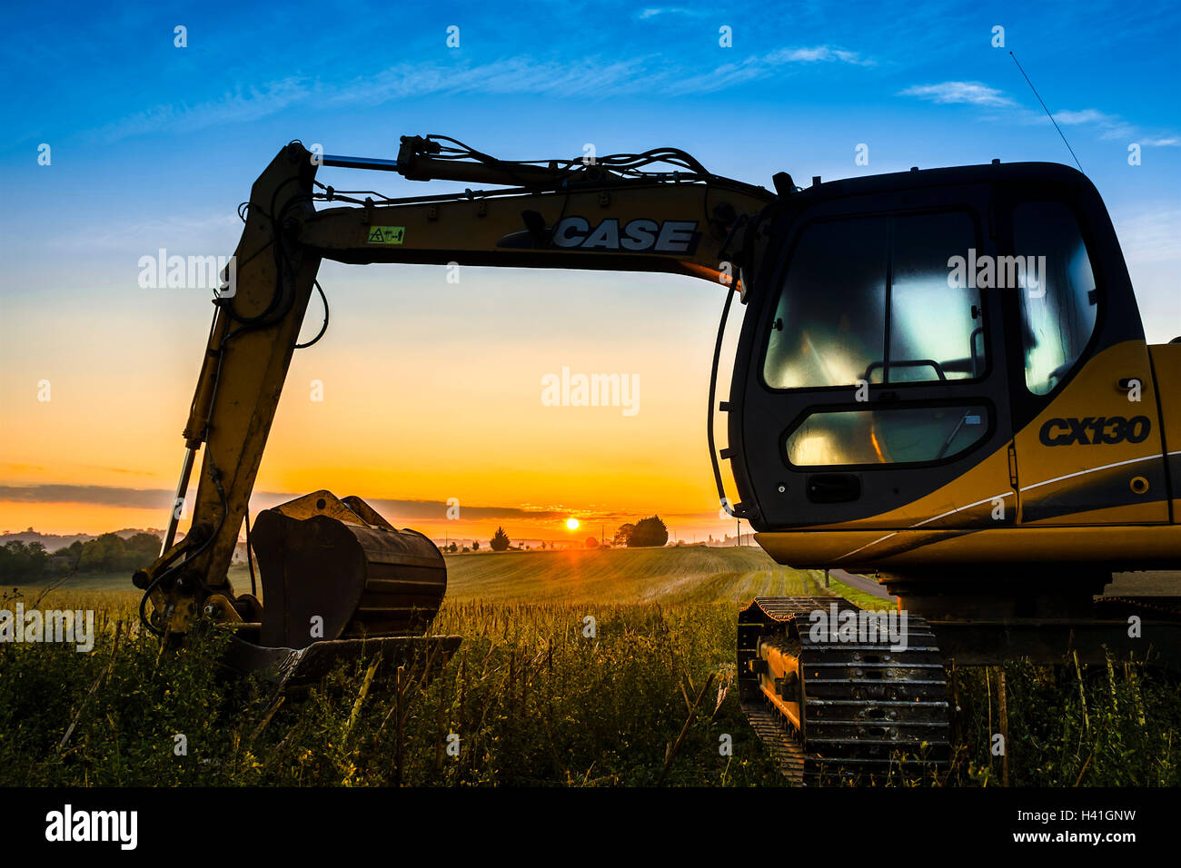 Case mechanical digger excavator at sunrise - France Stock Photo - Alamy