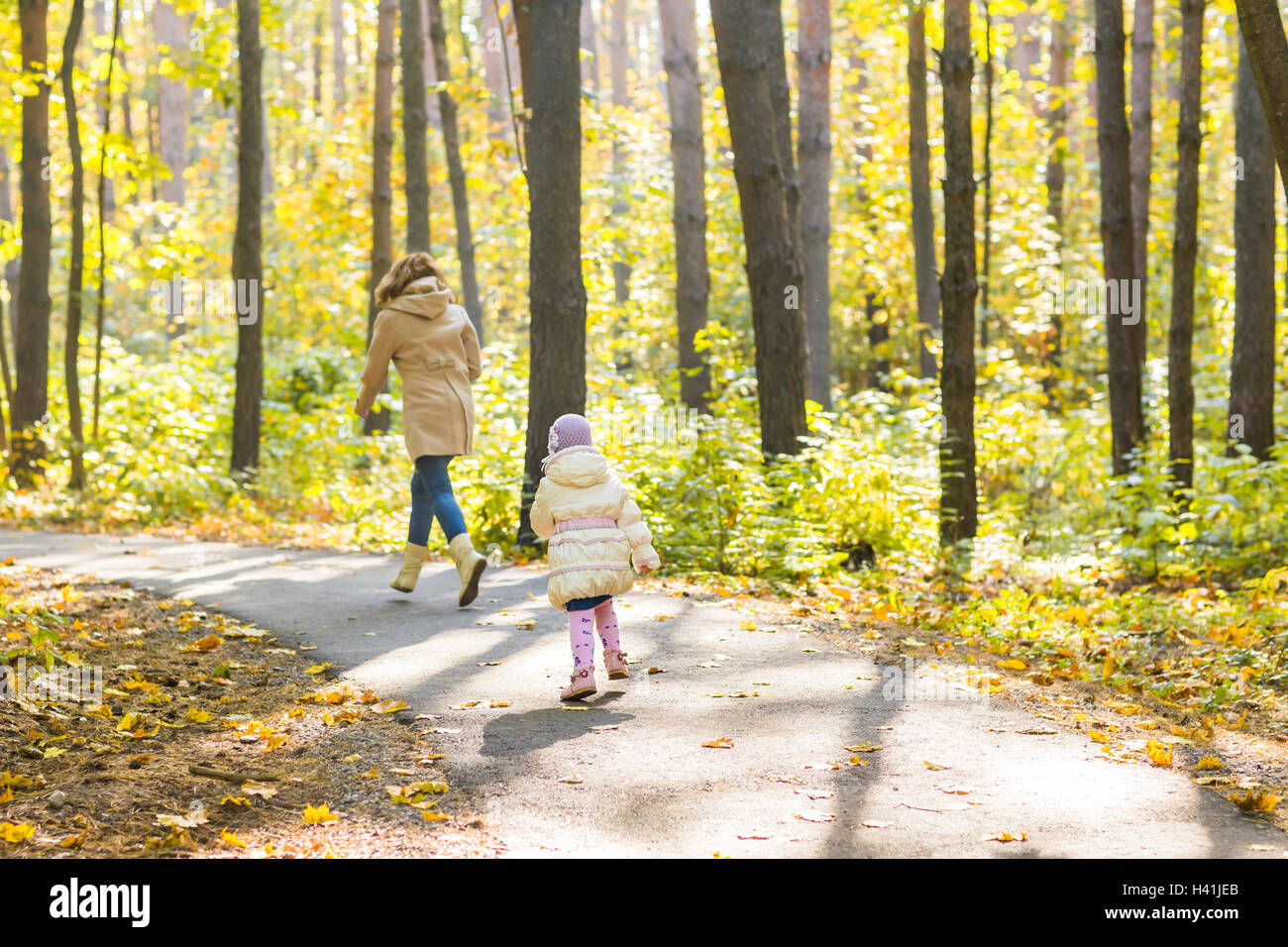 Adorable little kid girl and young woman in beautiful autumn forest ...