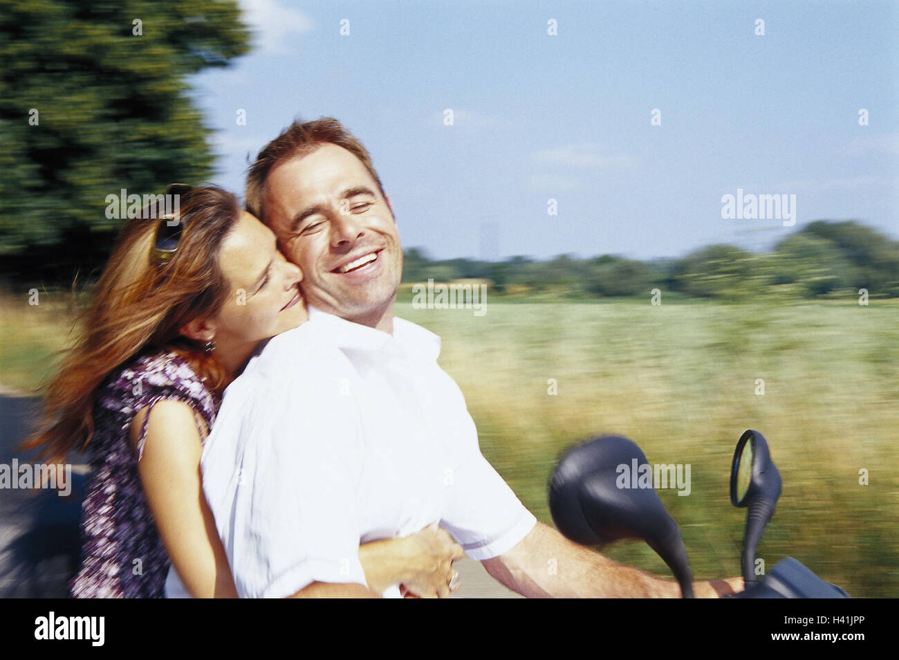 Couple, motor scooter, happy, half portrait, side view, country road ...