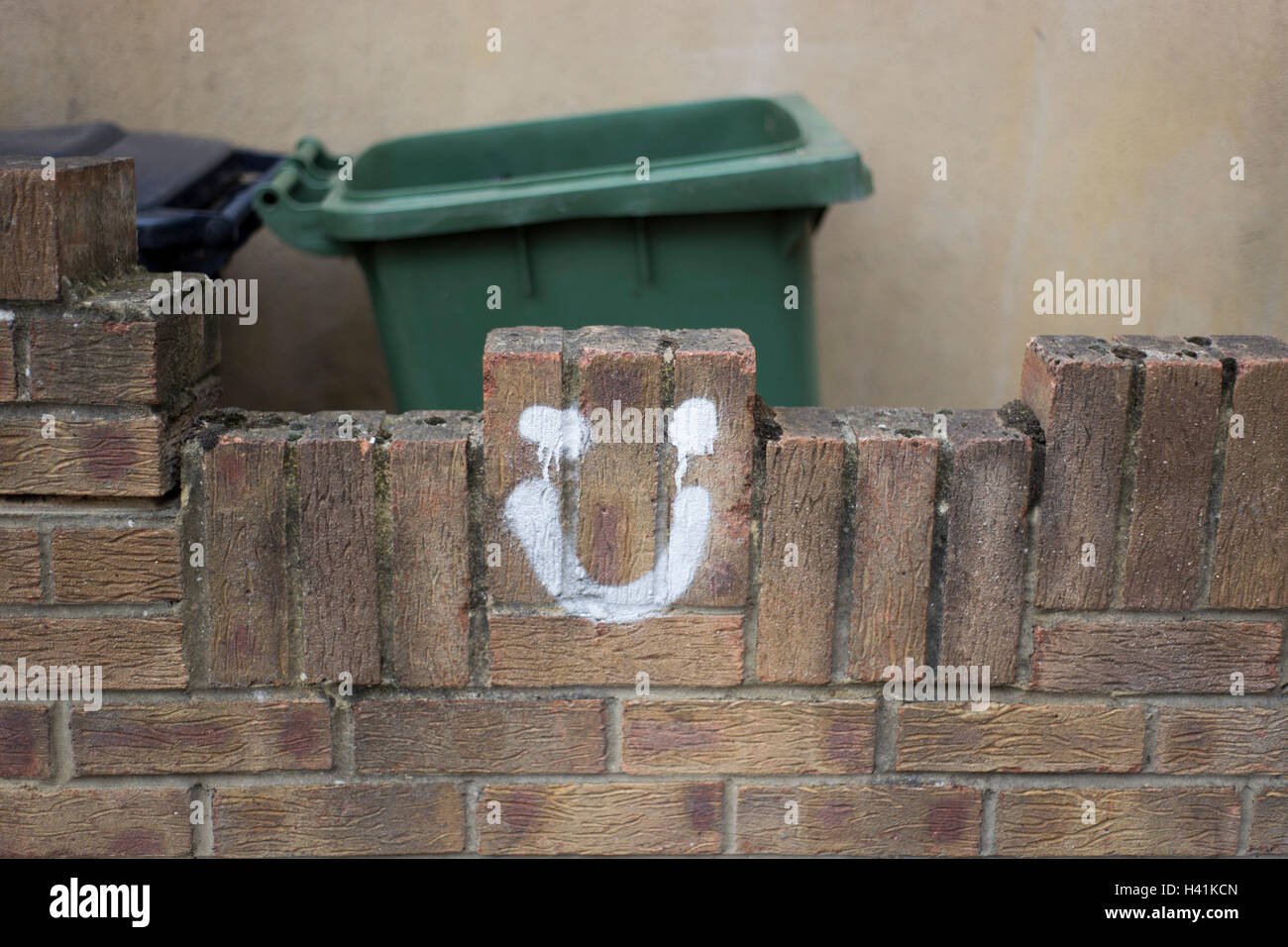 Smiley face graffiti'd on outside wall Stock Photo - Alamy