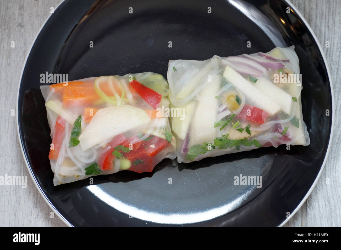 Spring rolls on a plate filled with colorful vegetables Stock Photo - Alamy