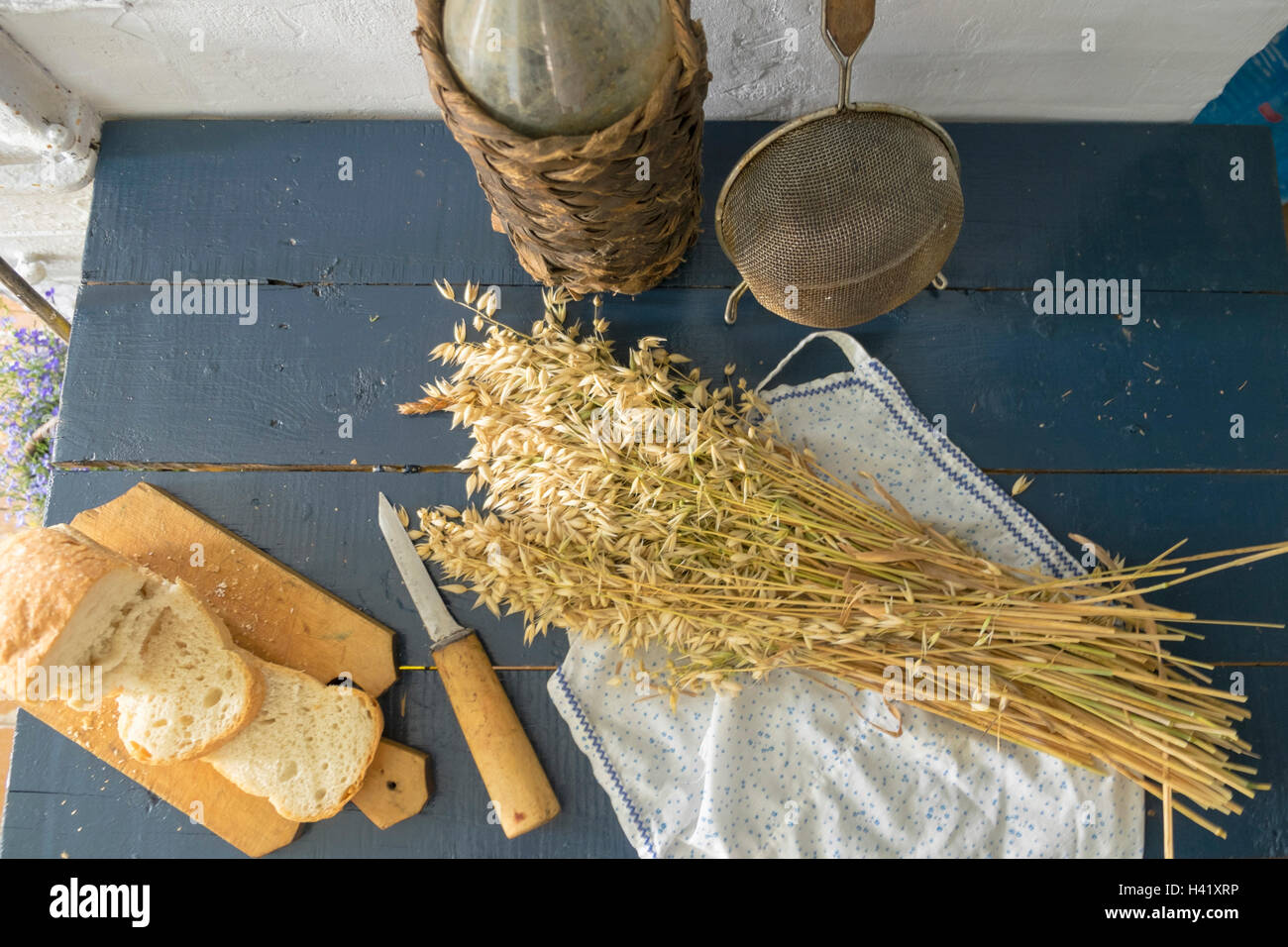 Wheat, sliced bread, sieve and bottle on bench Stock Photo - Alamy