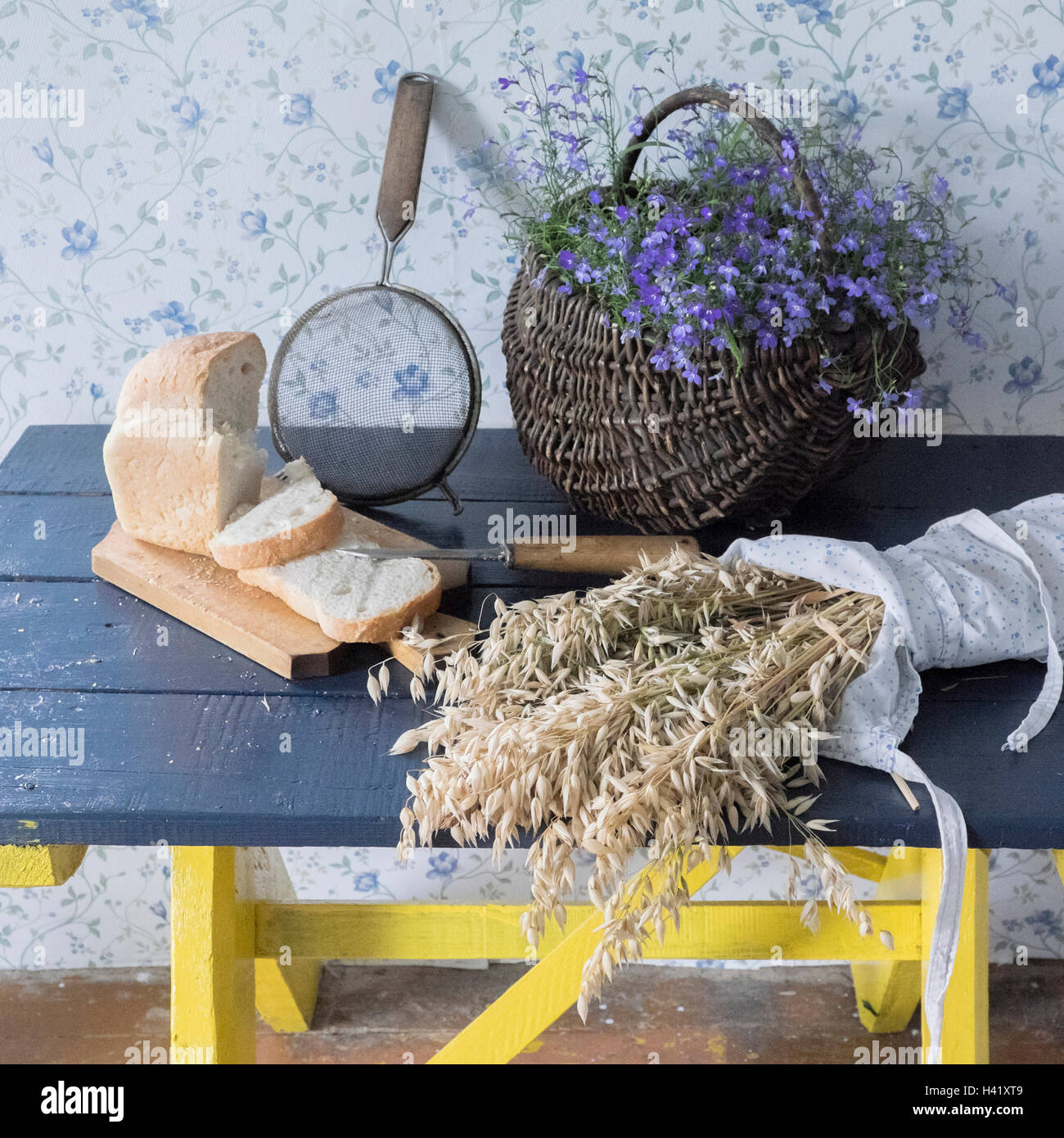 Wheat, sliced bread, sieve and flowers on bench Stock Photo - Alamy