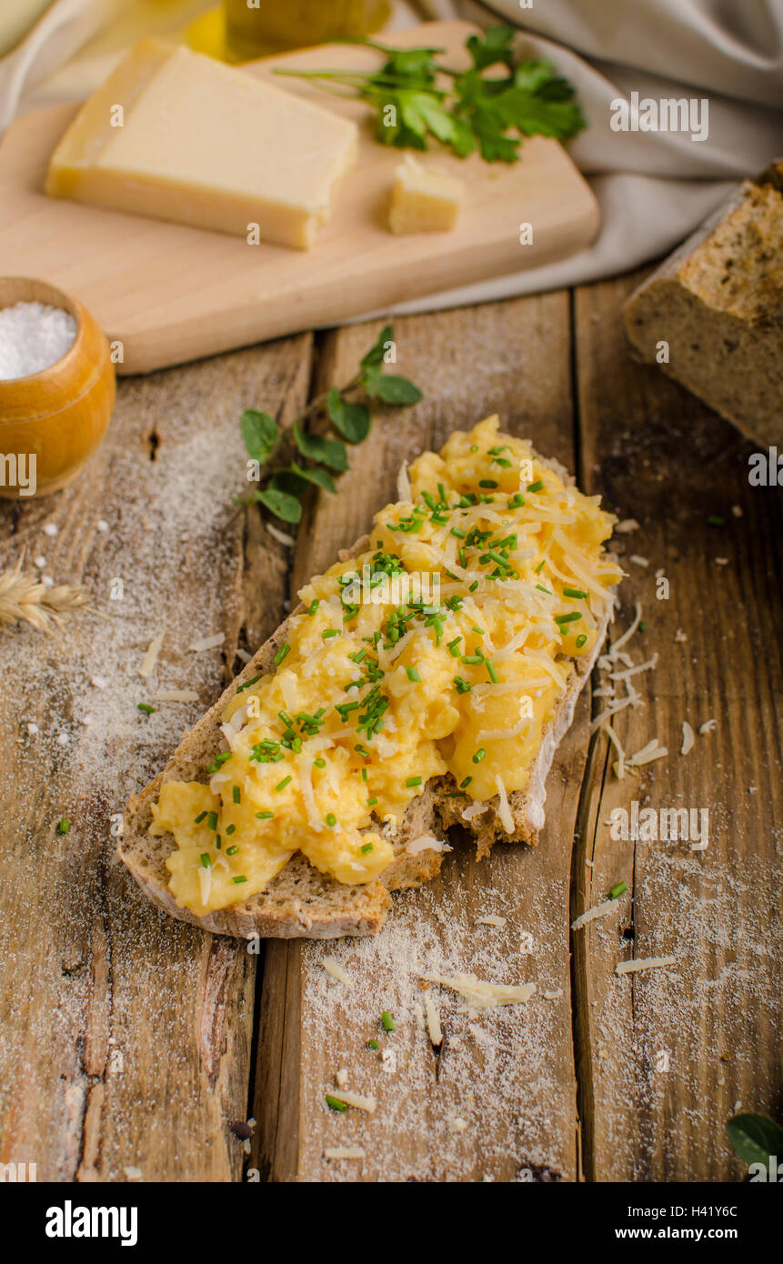 Scrambled eggs on homemade bread, beautiful rustic bread baked home in ...