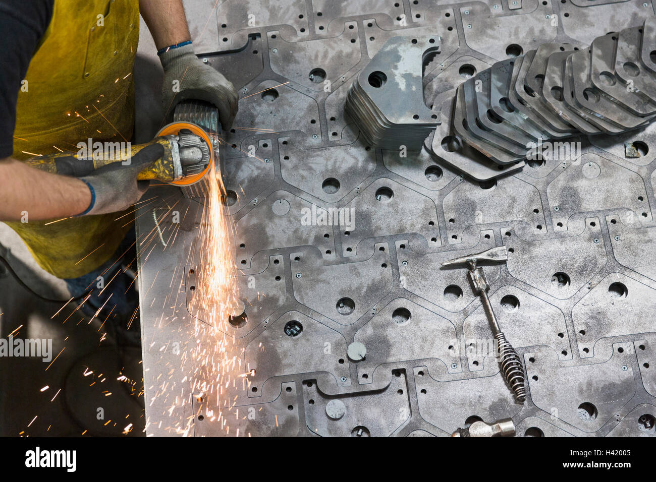 Caucasian worker grinding metal in factory Stock Photo - Alamy