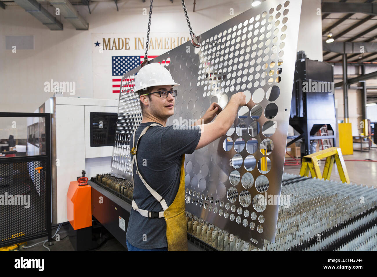 Caucasian worker fabricating metal in factory Stock Photo - Alamy
