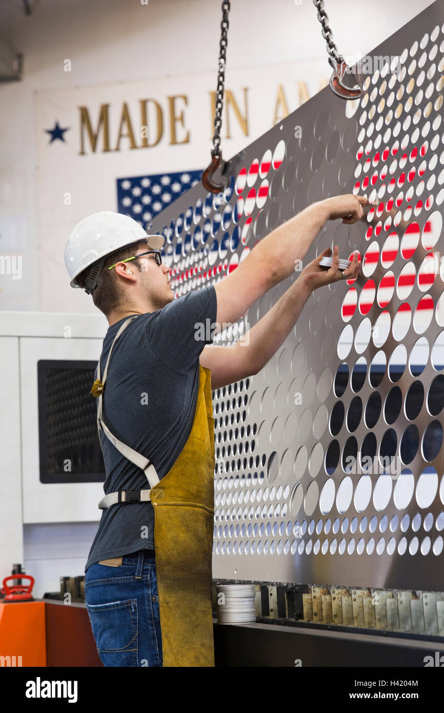 Caucasian worker fabricating metal in factory Stock Photo - Alamy