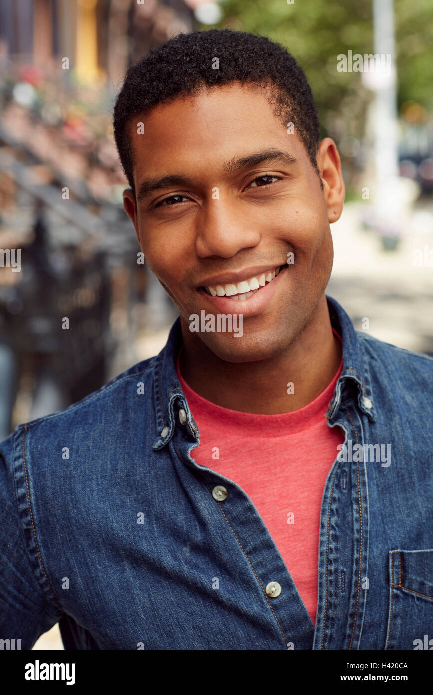 Smiling man posing on city sidewalk Stock Photo - Alamy