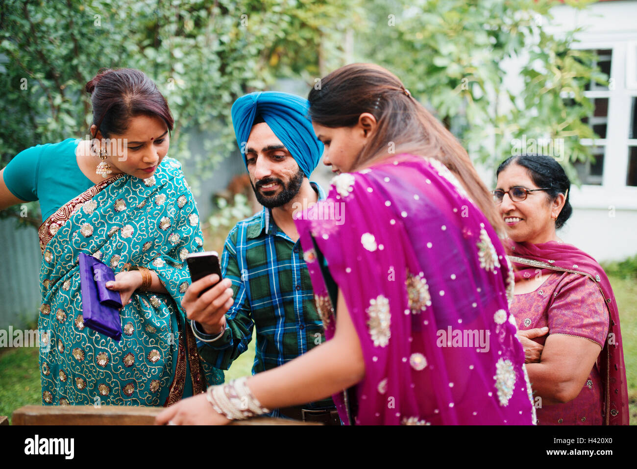 Family using cell phone in backyard Stock Photo - Alamy