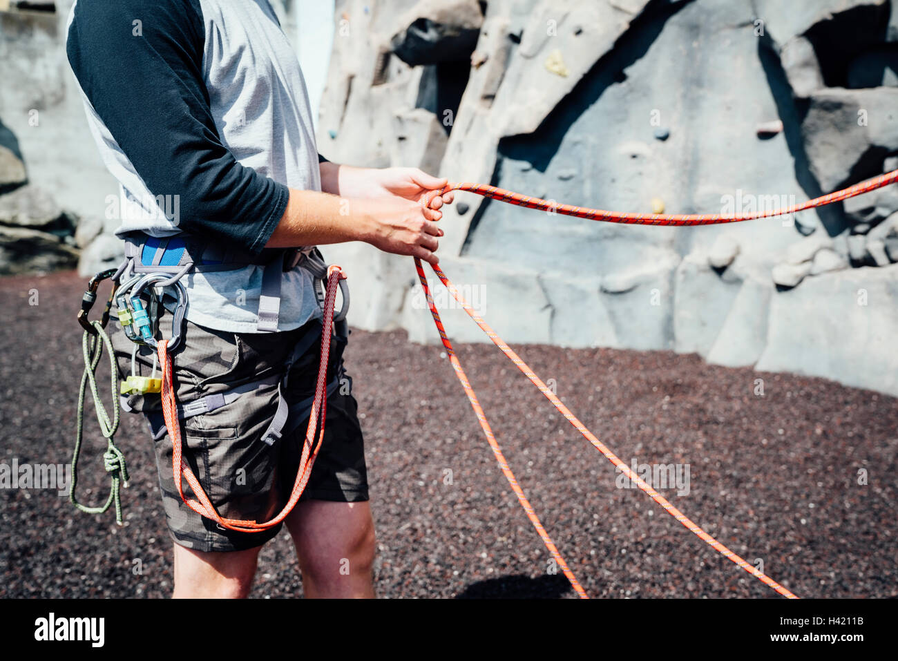 Caucasian man holding ropes at rock climbing wall Stock Photo - Alamy
