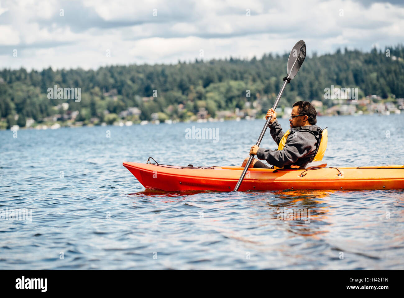 Mixed Race man paddling kayak Stock Photo - Alamy