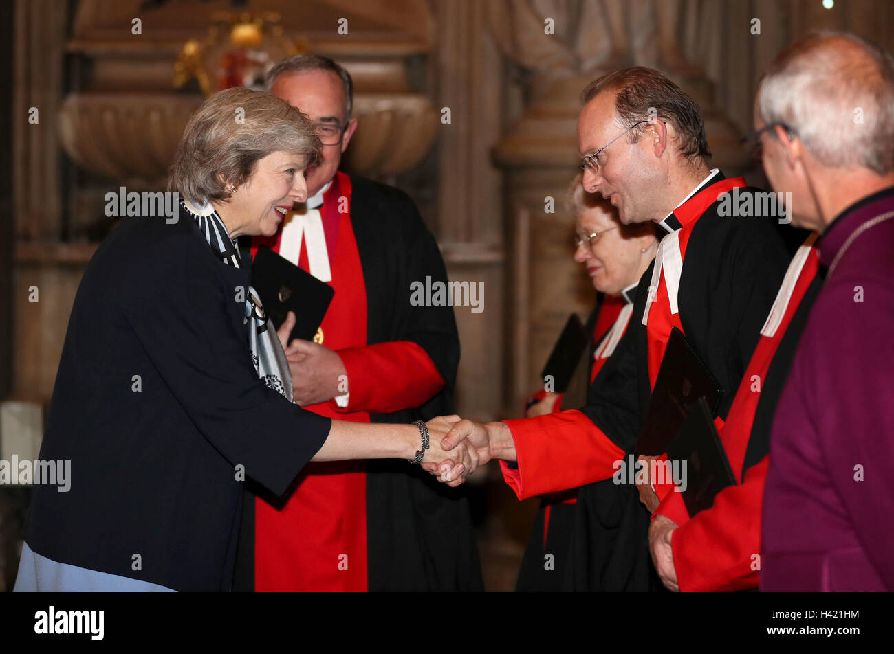 Prime Minister Theresa May is greeted by Canon Athony Ball as she ...