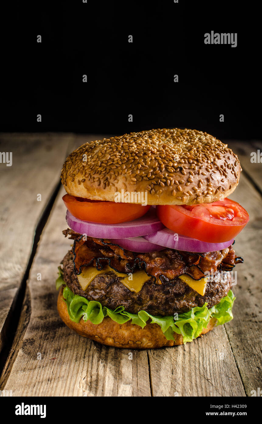 American rustic bacon burger with cheddar, beef, salad and vegetable ...