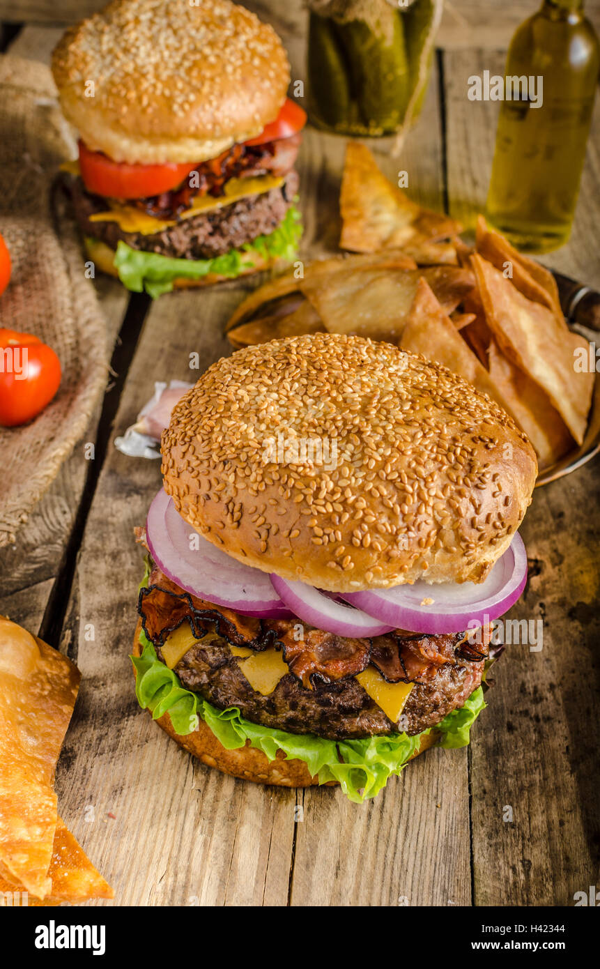 American rustic bacon burger with cheddar, beef, salad and vegetable ...