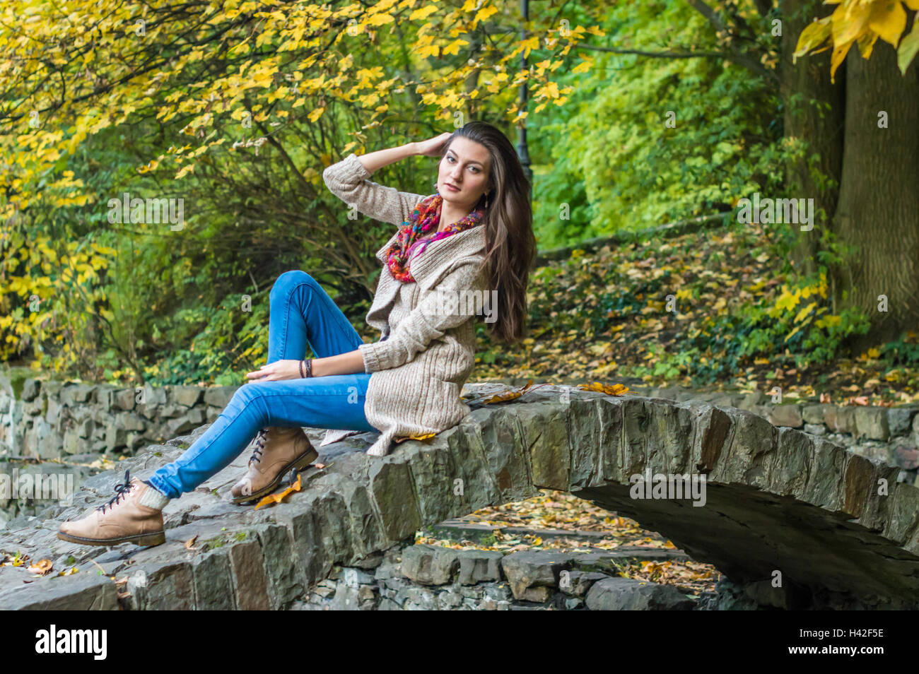 beauty girl sitting on bridge Stock Photo - Alamy