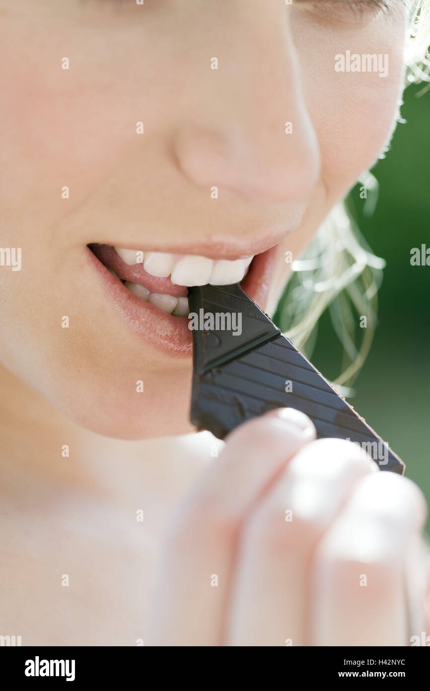 Woman, young, bite, chocolate, medium close-up Stock Photo - Alamy