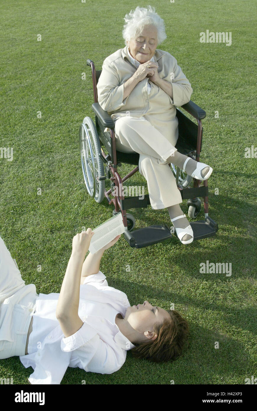 Senior, invalid, wheel chair, old nurse, meadow, lie, read out book ...