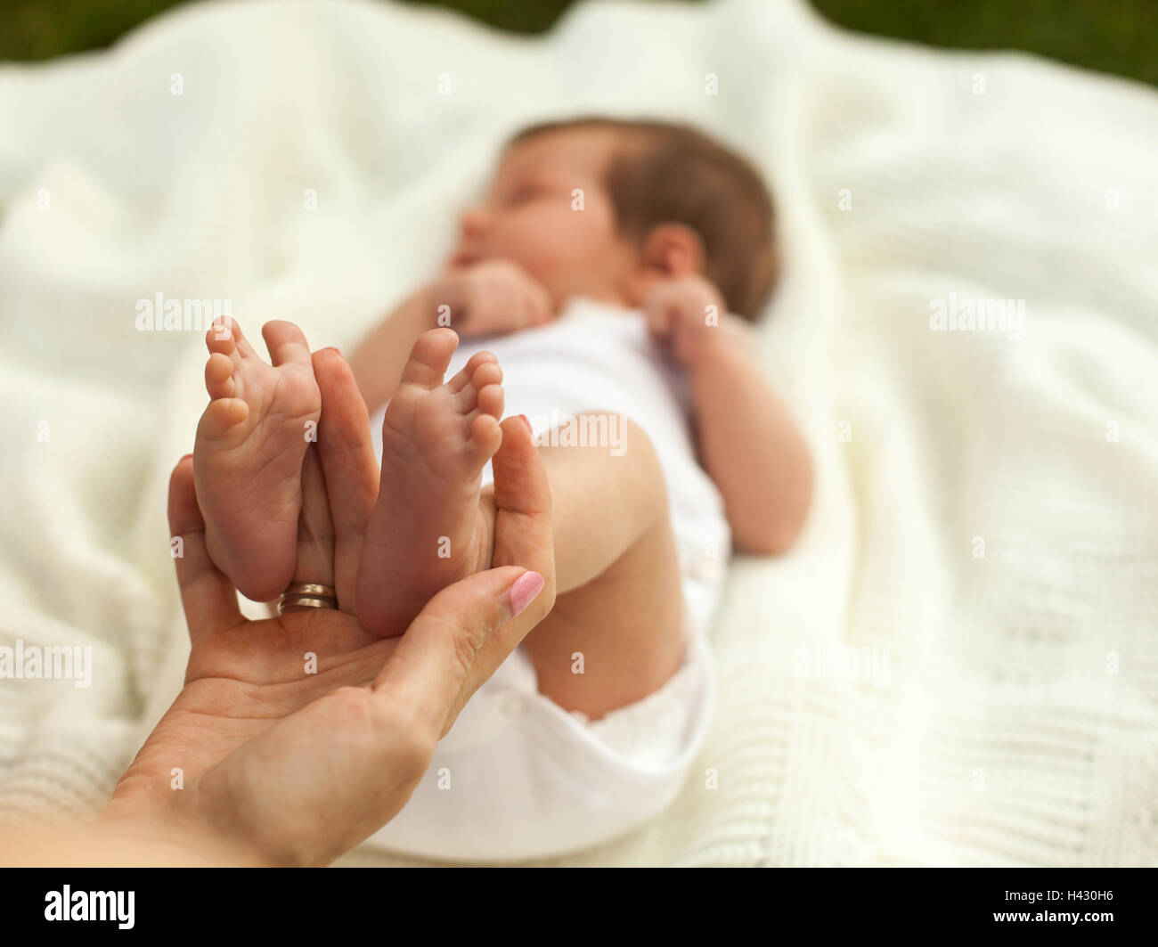 Hand holding little baby's legs Stock Photo - Alamy