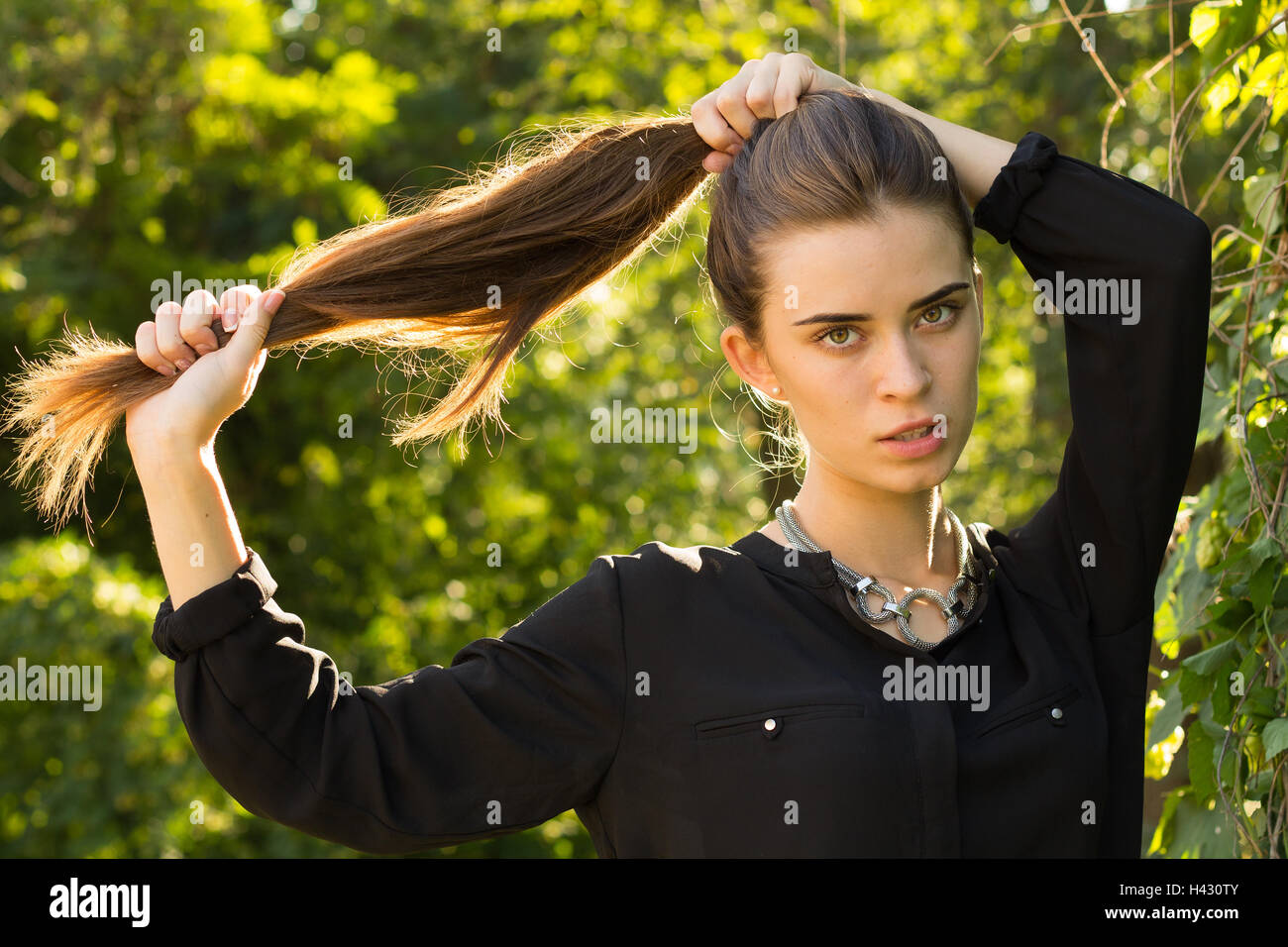 Young woman fixing her hair Stock Photo - Alamy