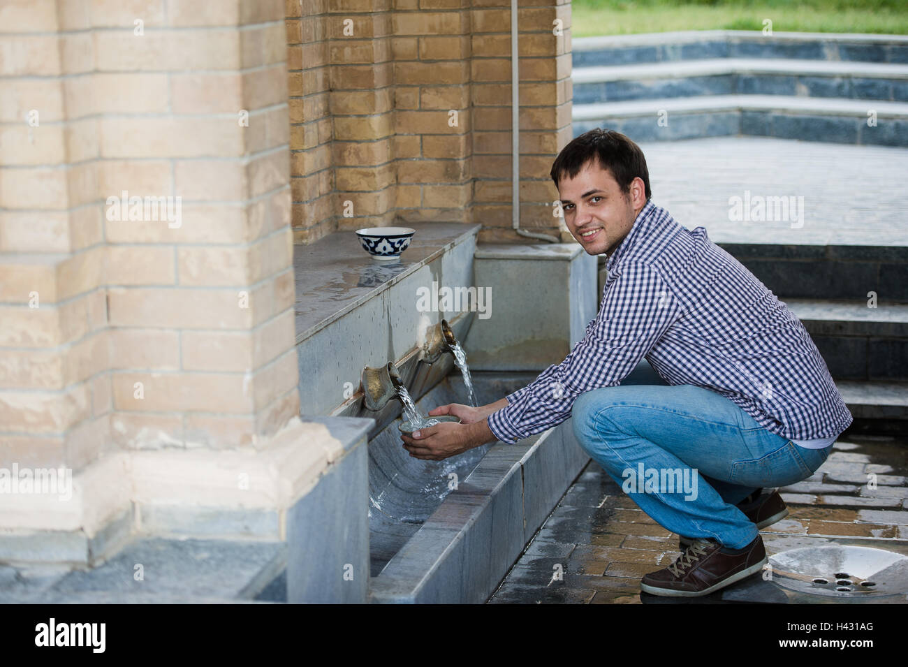 man drink fresh water from spring in the village Stock Photo - Alamy