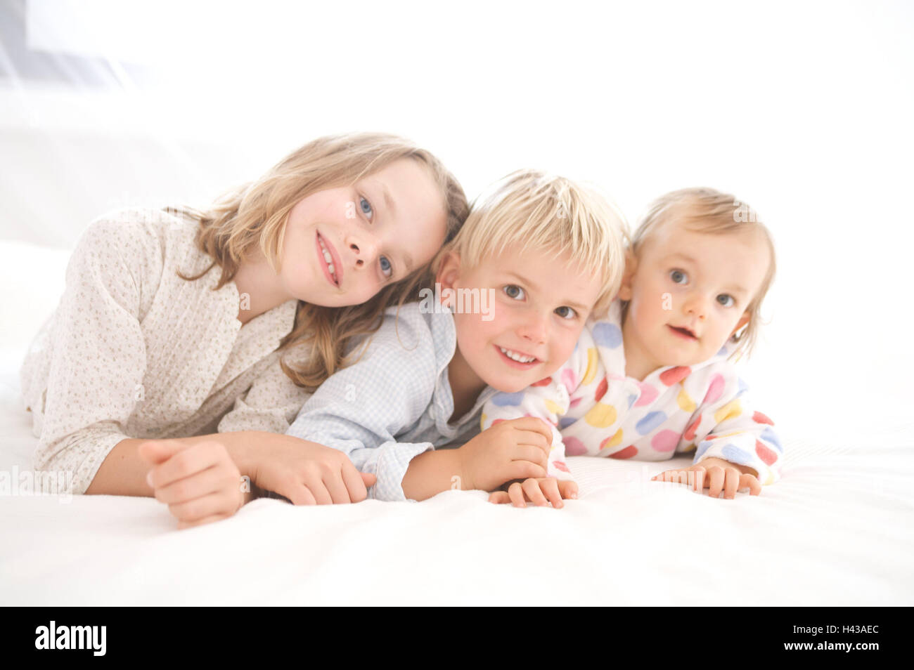 Children, three, pyjamas, bed, lying, smiling, looking at camera Stock ...