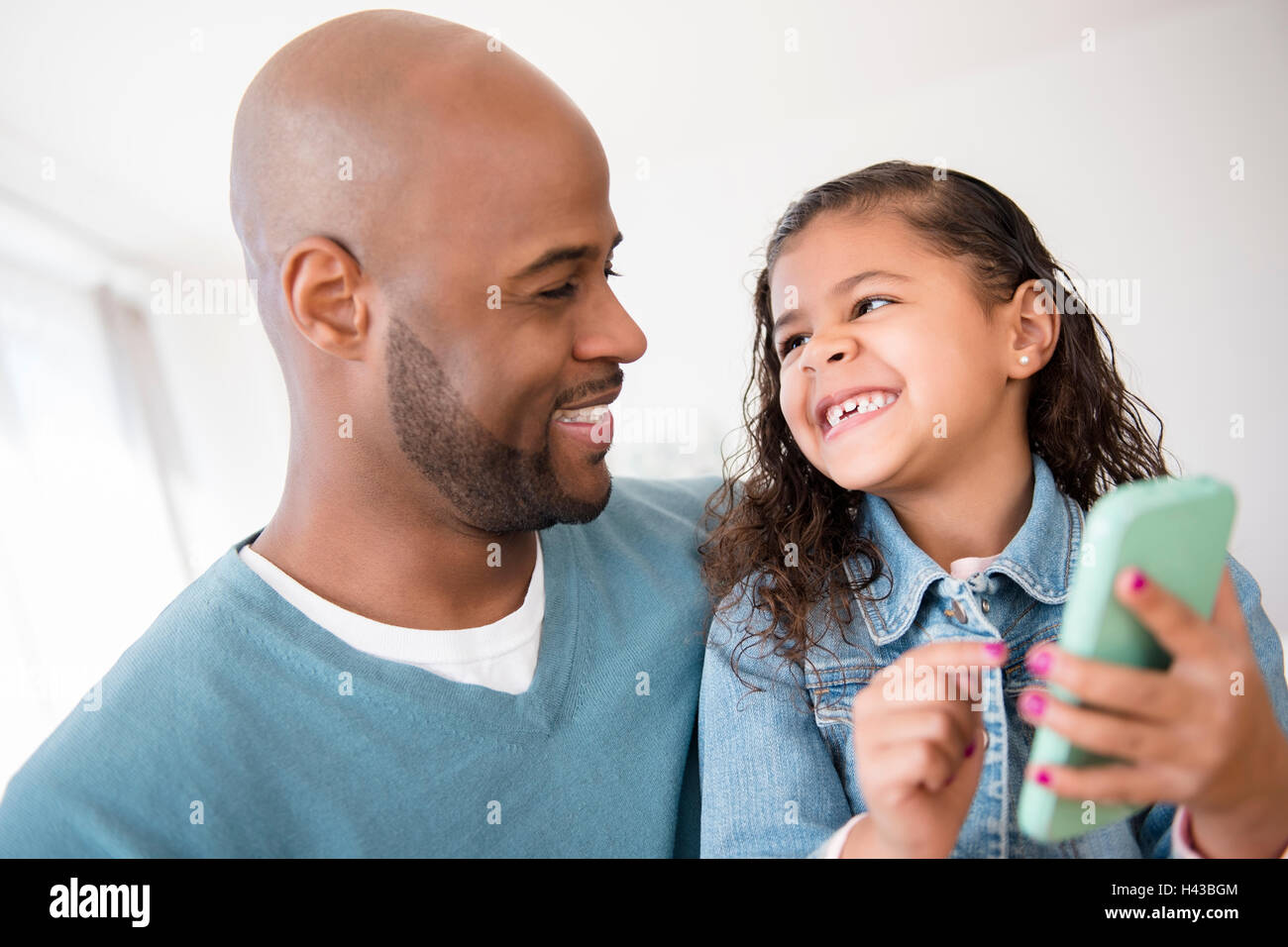 Father and daughter texting on cell phone Stock Photo - Alamy
