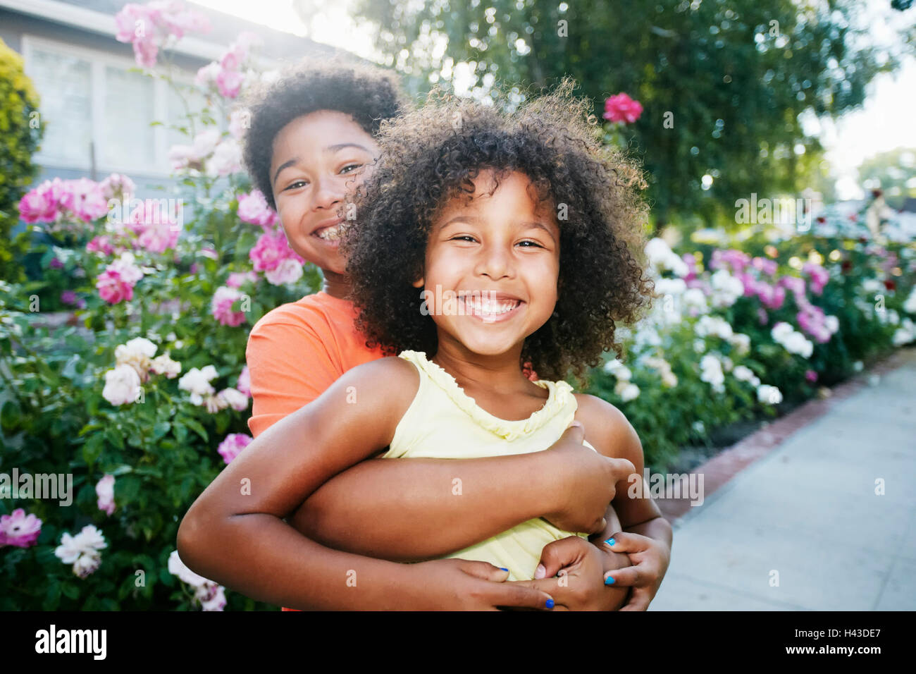 Mixed Race brother hugging sister outdoors Stock Photo - Alamy