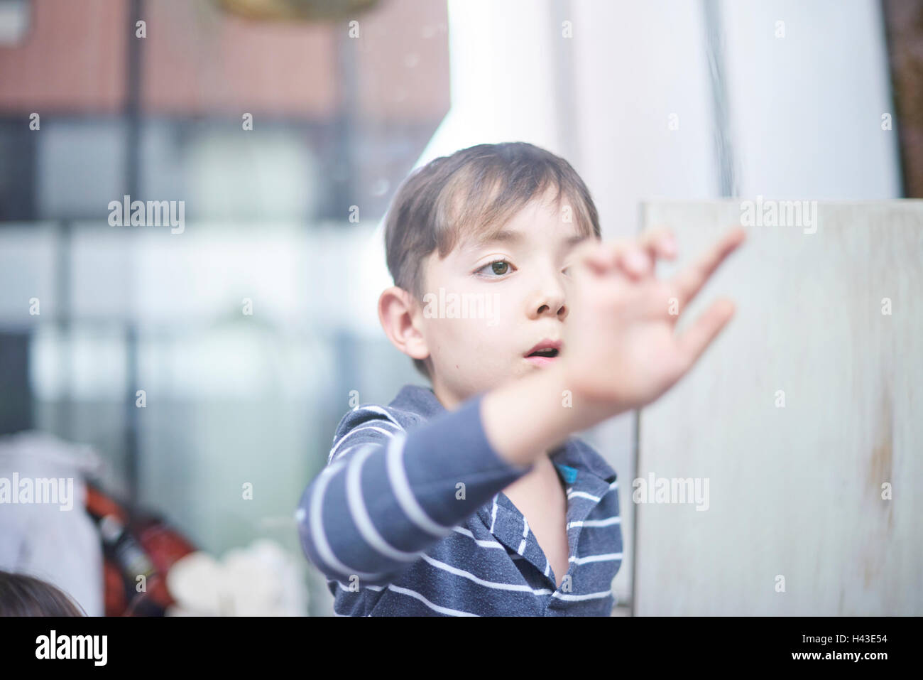 Hispanic boy touching window Stock Photo - Alamy