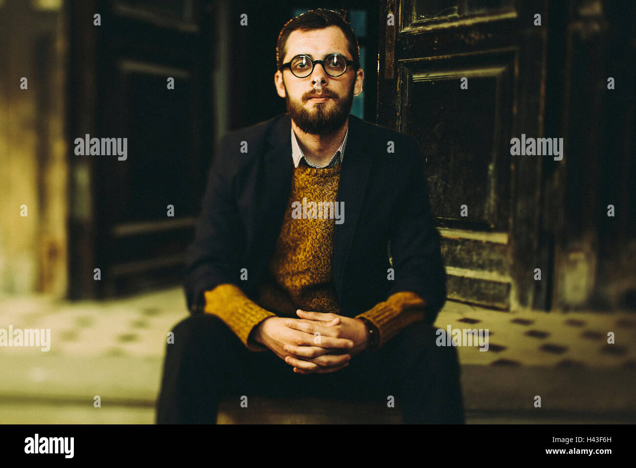 Caucasian man with beard sitting on front stoop Stock Photo - Alamy