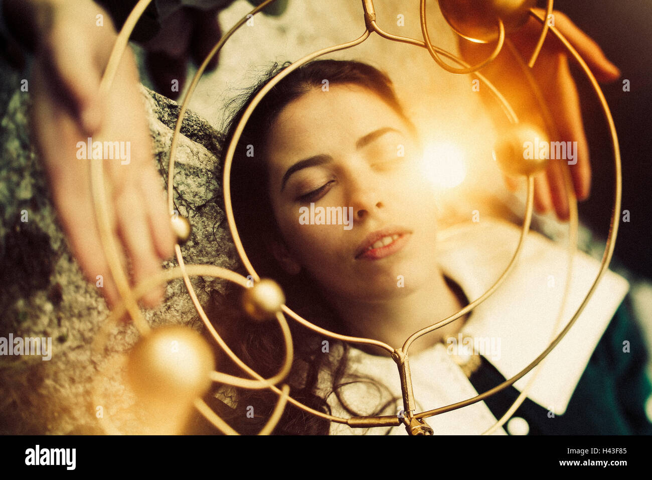 Hands holding metal circle over face of Caucasian woman Stock Photo - Alamy
