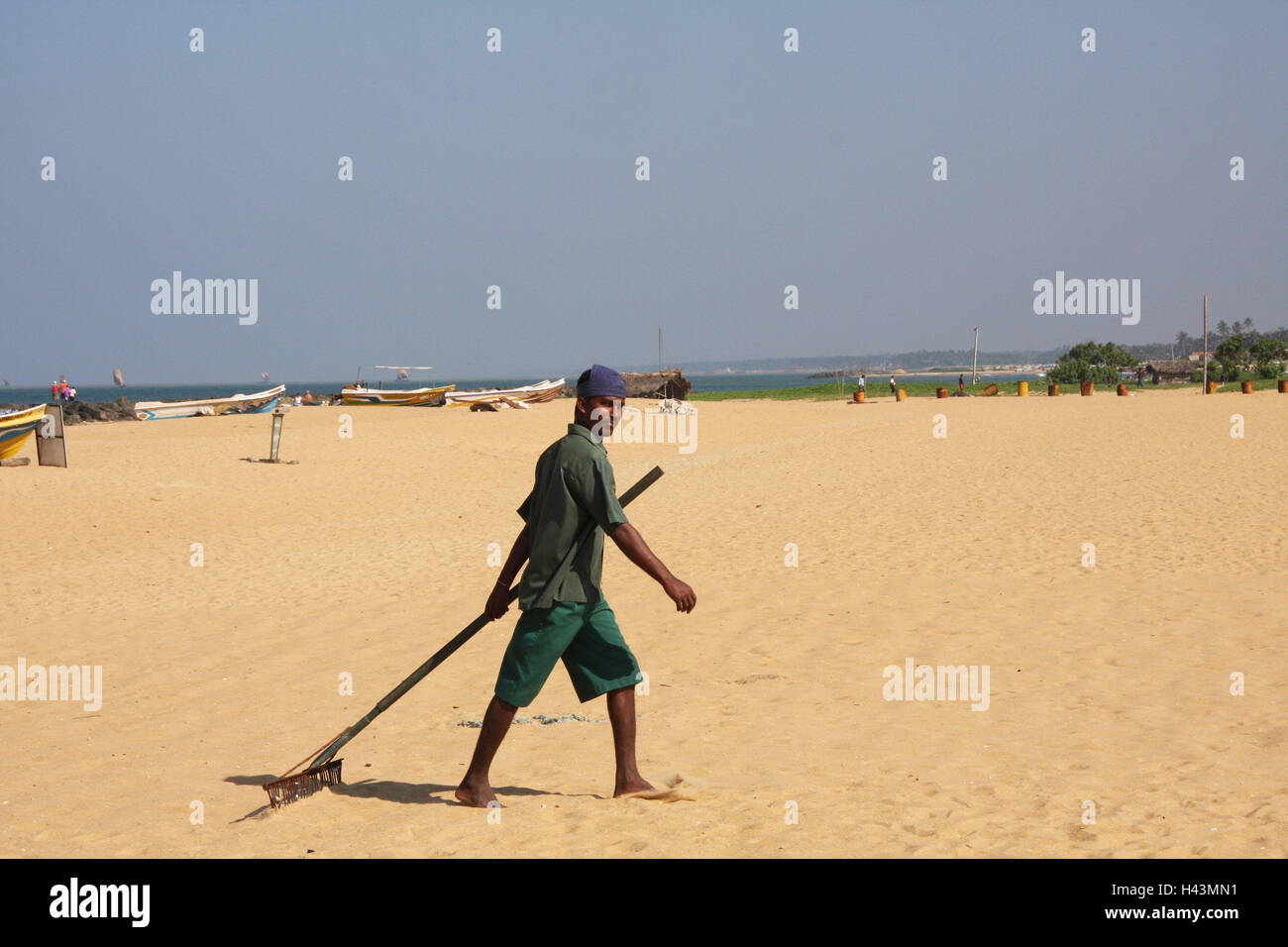Sri Lanka, Negombo, sandy beach, man, rake, no model release ...