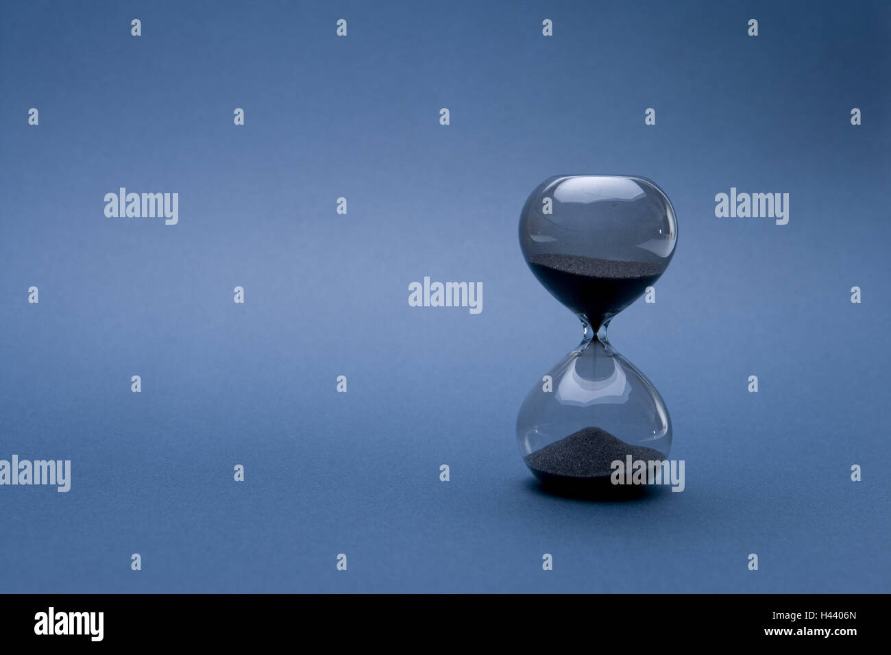 Hourglass blue background hi-res stock photography and images - Alamy