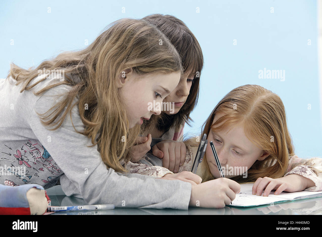 Girls, three, homework, write, together Stock Photo - Alamy